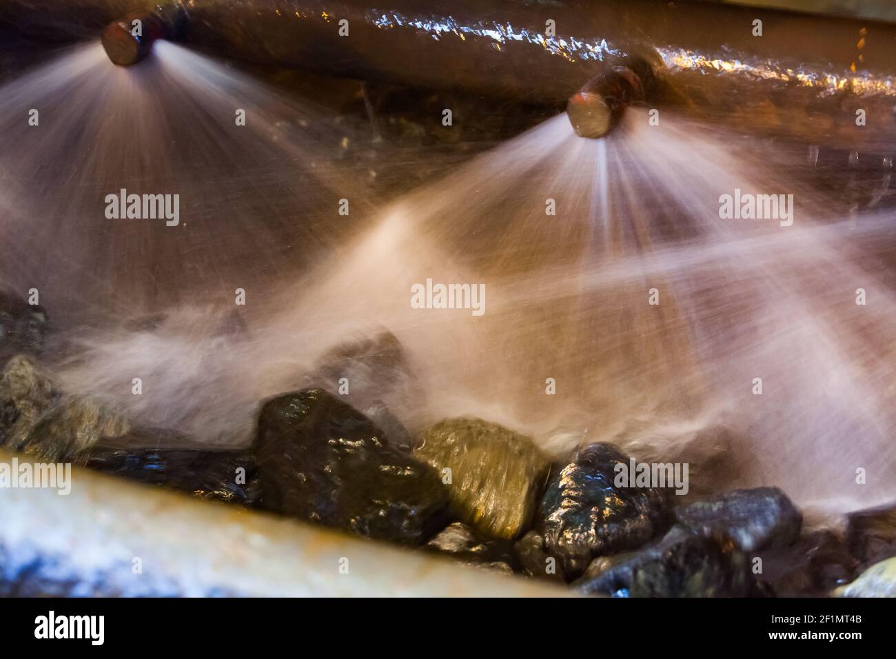 Blurred photo background. Water jets and ore rocks. Washing gold ore on ...