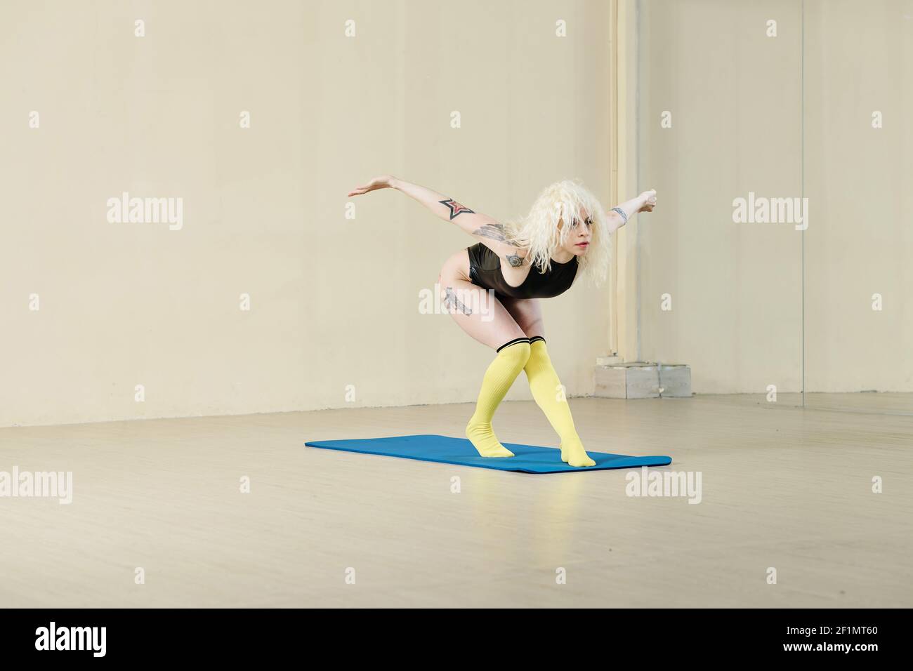 Pretty fit female dancer practicing new movement during dance class for ...