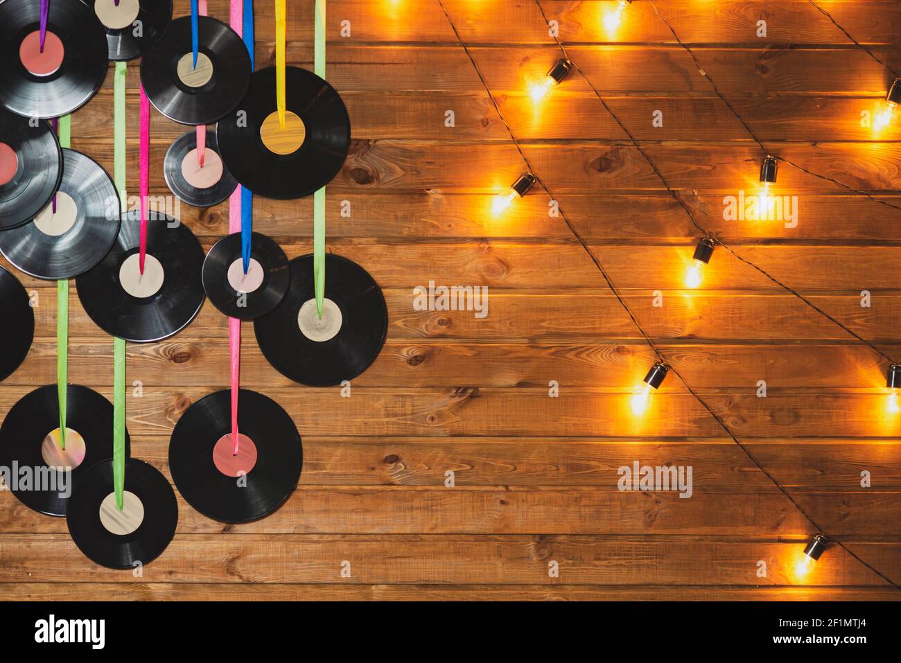 Wooden background with hanging light bulbs and round records for ...