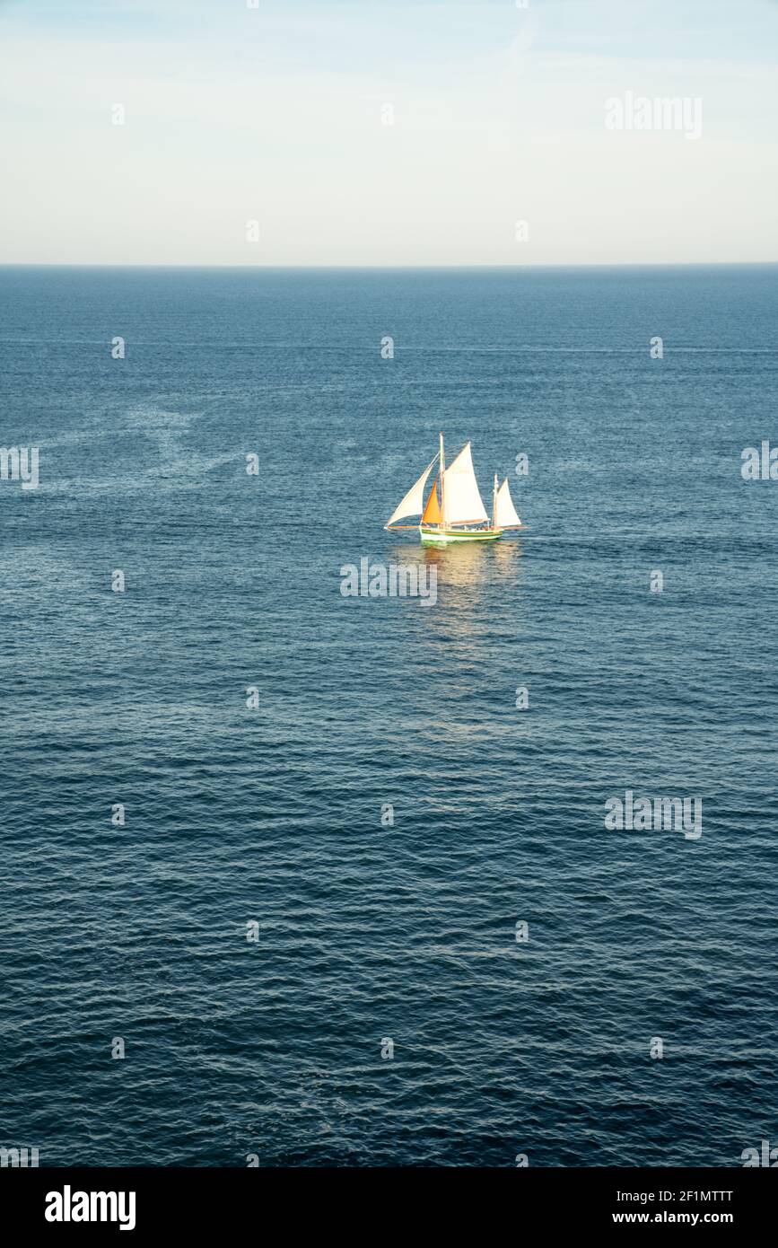 Wooden sailboat sailing across a deep blue ocean Stock Photo - Alamy