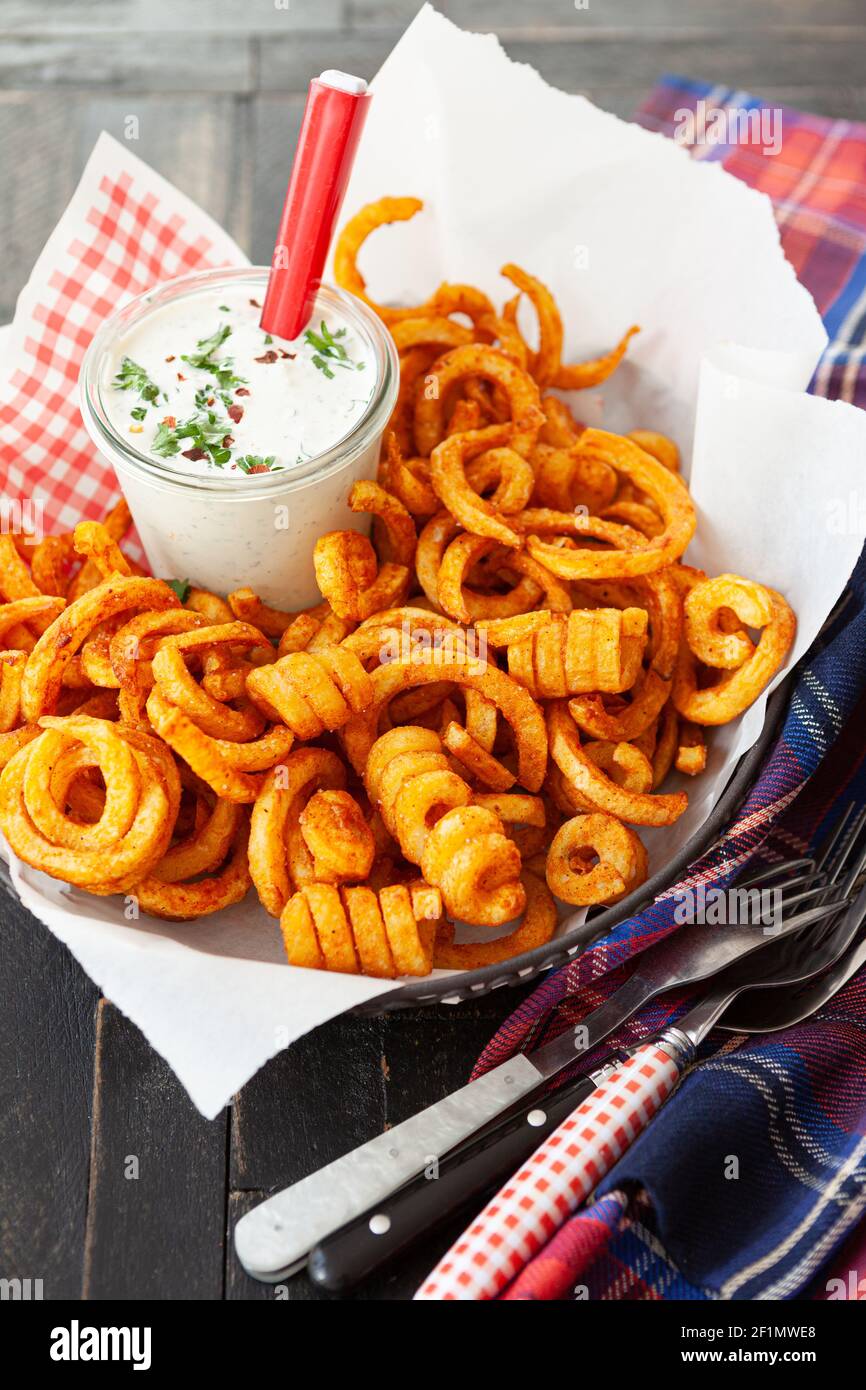 Curly fries, twisted fries with dip Stock Photo - Alamy