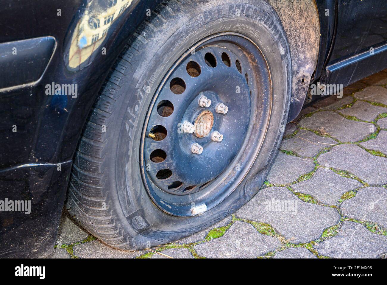 A defective tire that needs to be replaced. The tire is flat. The car ...
