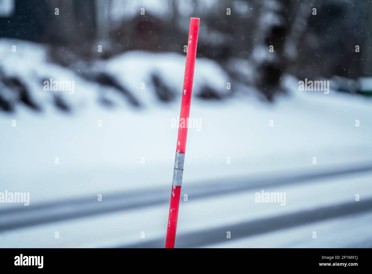 Road marking stick by the side of a road covered in snow and ice Stock ...
