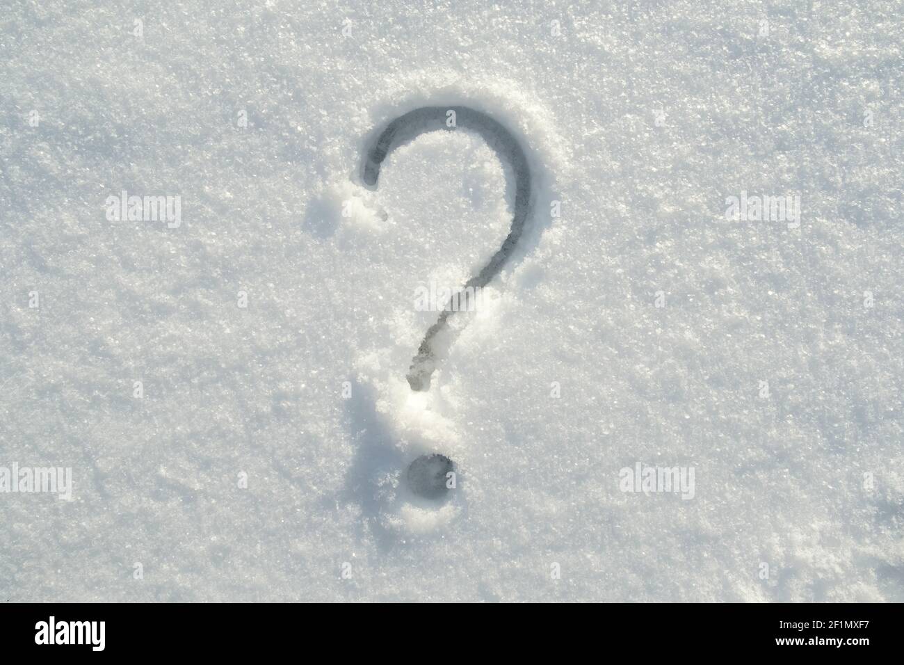 Punctuation question mark drawn on the fresh snow on a sunny winter day ...