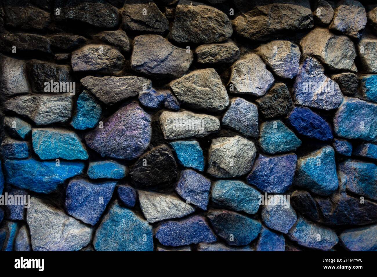 The wall of large natural stones with a blue-purple hue. Natural ...