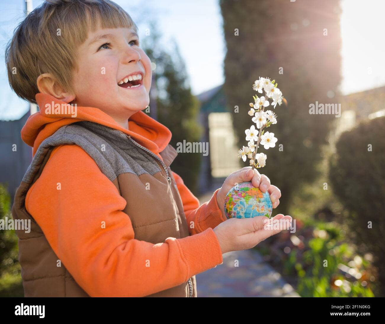 cute laughing boy of 4 years old holds small ball - globe from which ...