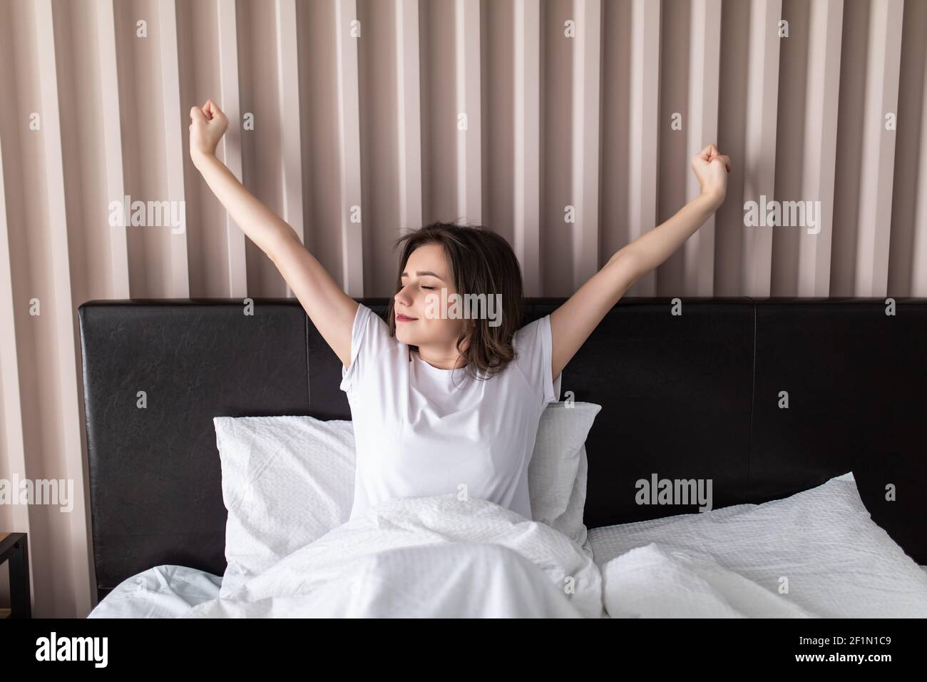 Woman stretching in bed after wake up Stock Photo - Alamy