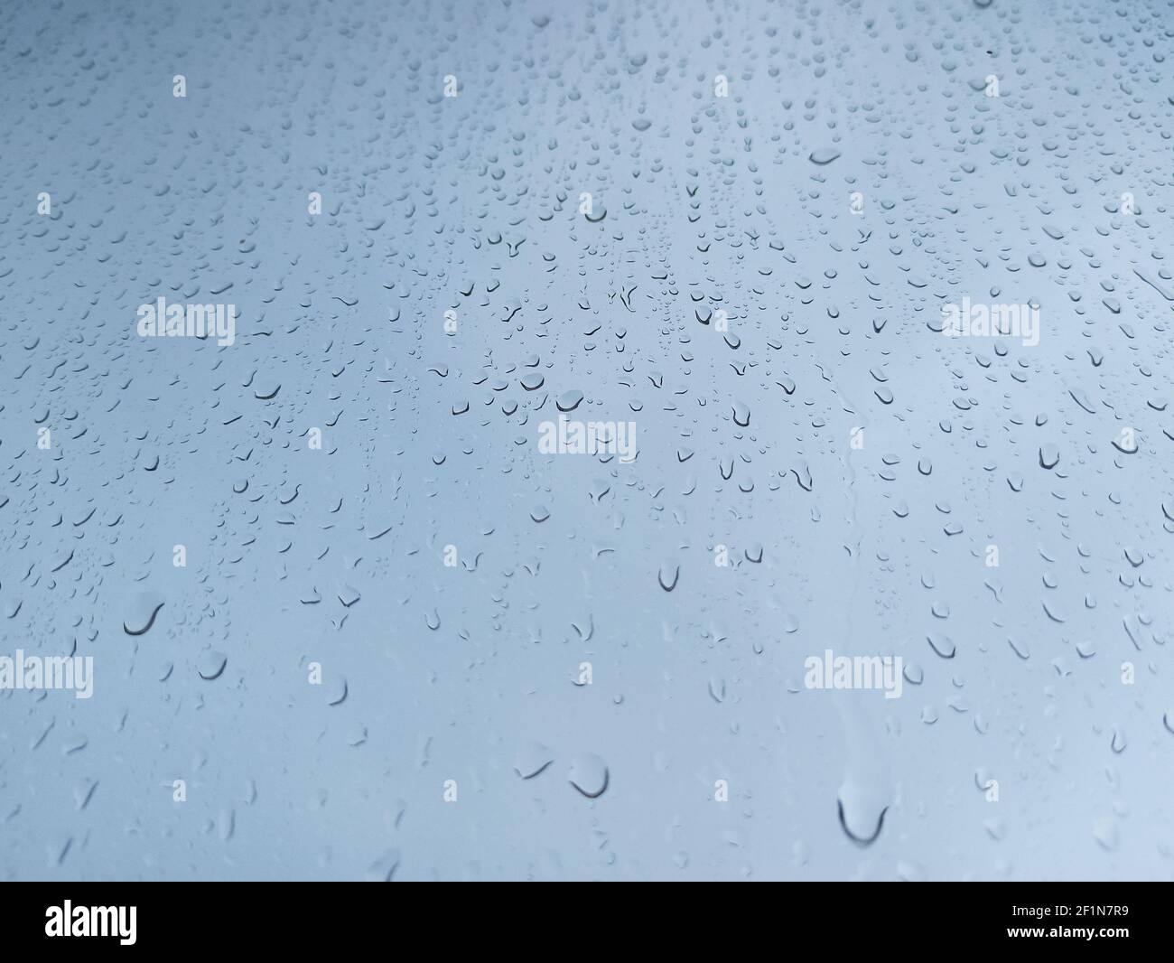 Raindrops on a window pane close-up. Abstract blue background Stock Photo - Alamy