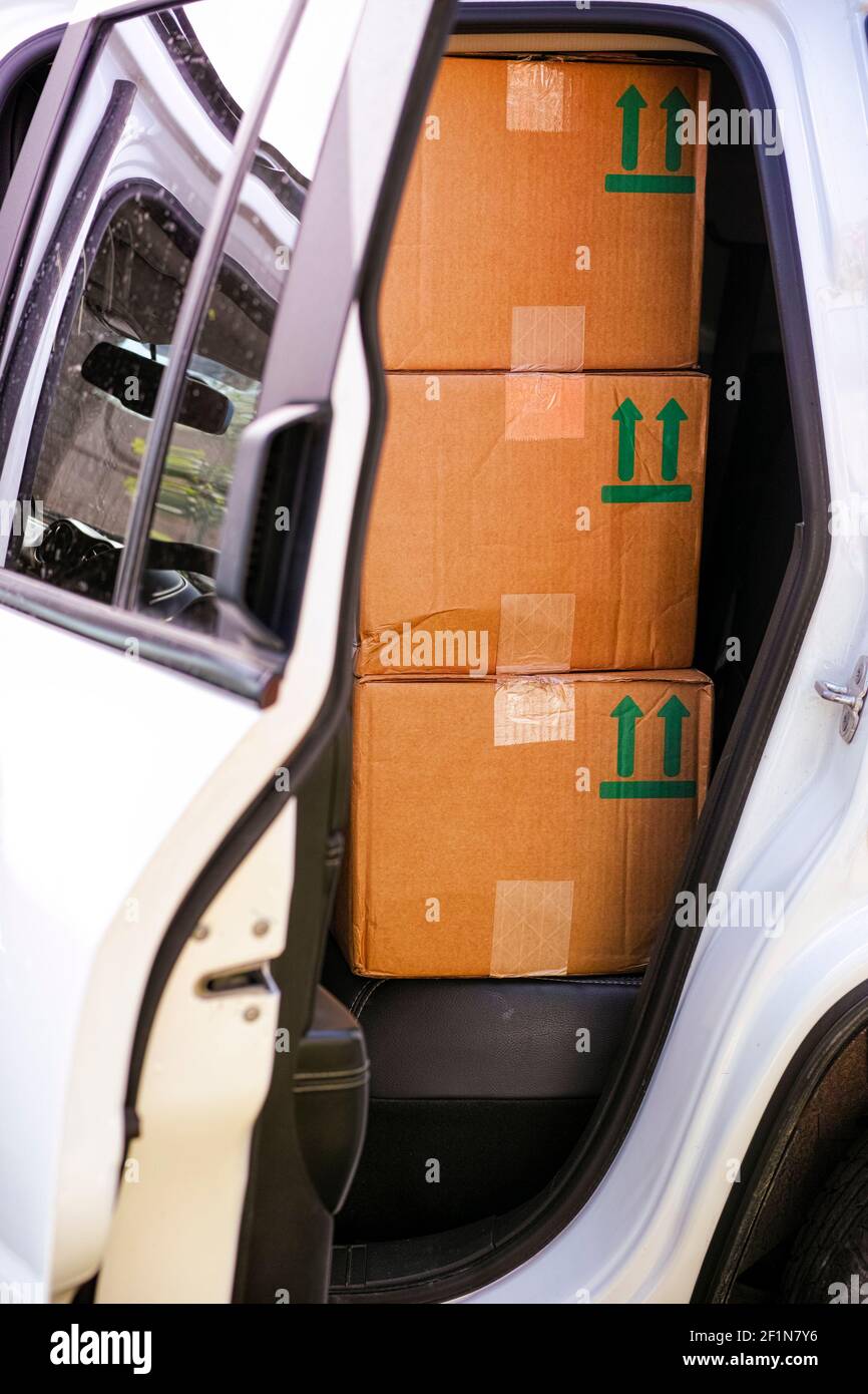 Stack of cardboard boxes on the back seat of white car Stock Photo - Alamy