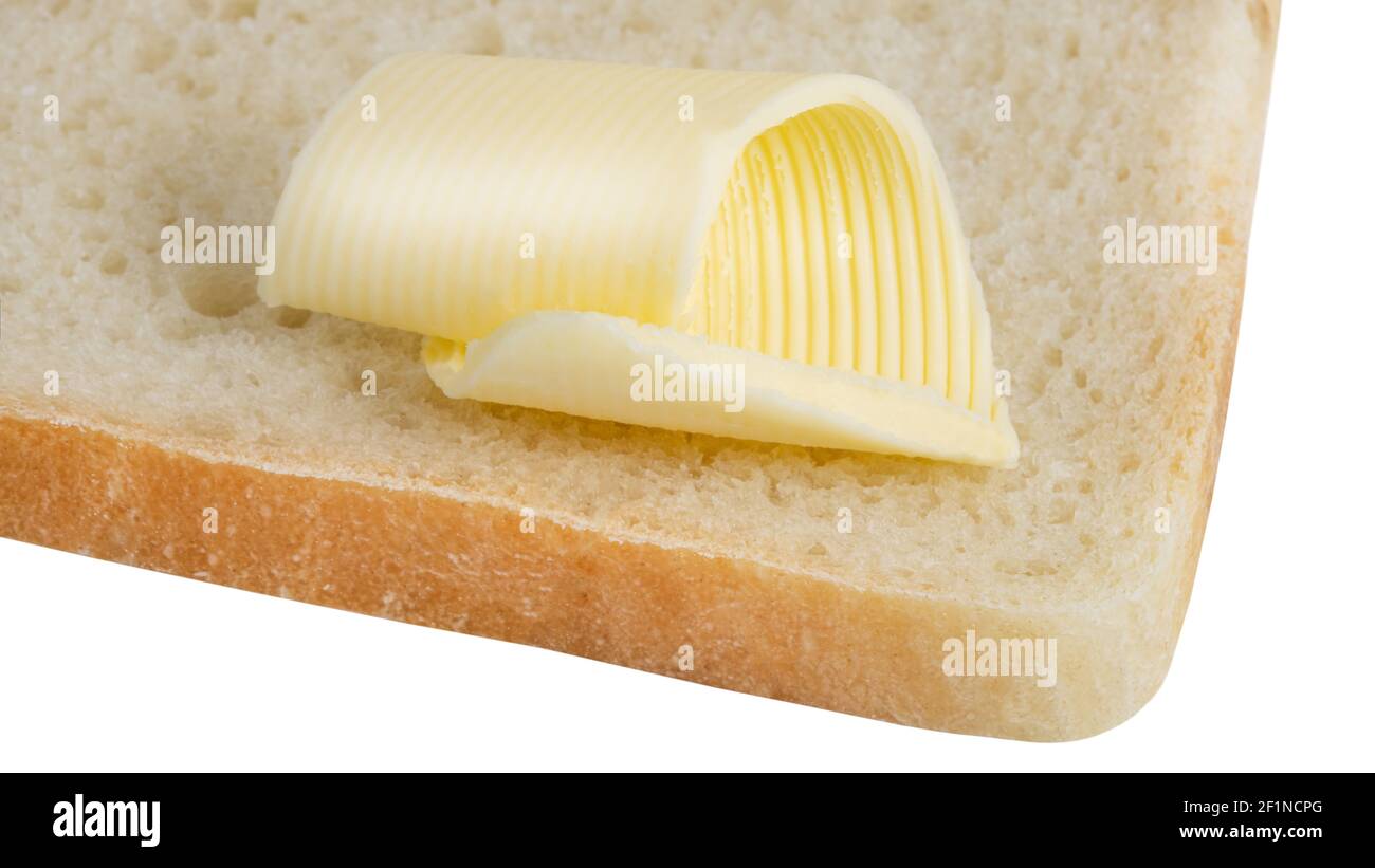 Slice of bread with butter curls on white background Stock Photo - Alamy
