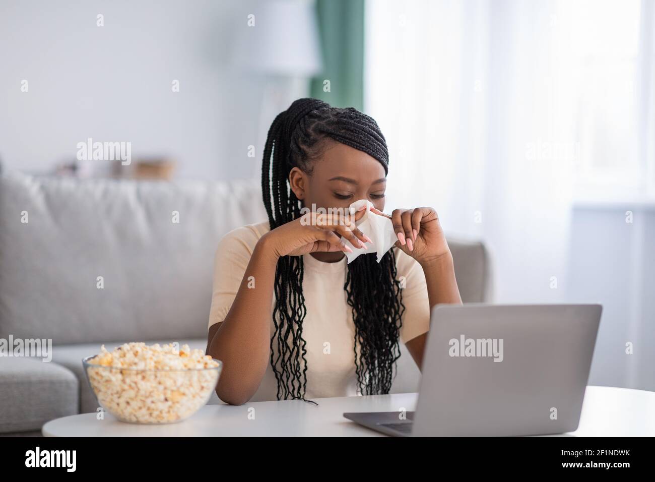 Sad african american woman weeping and sneezing nose while watching ...