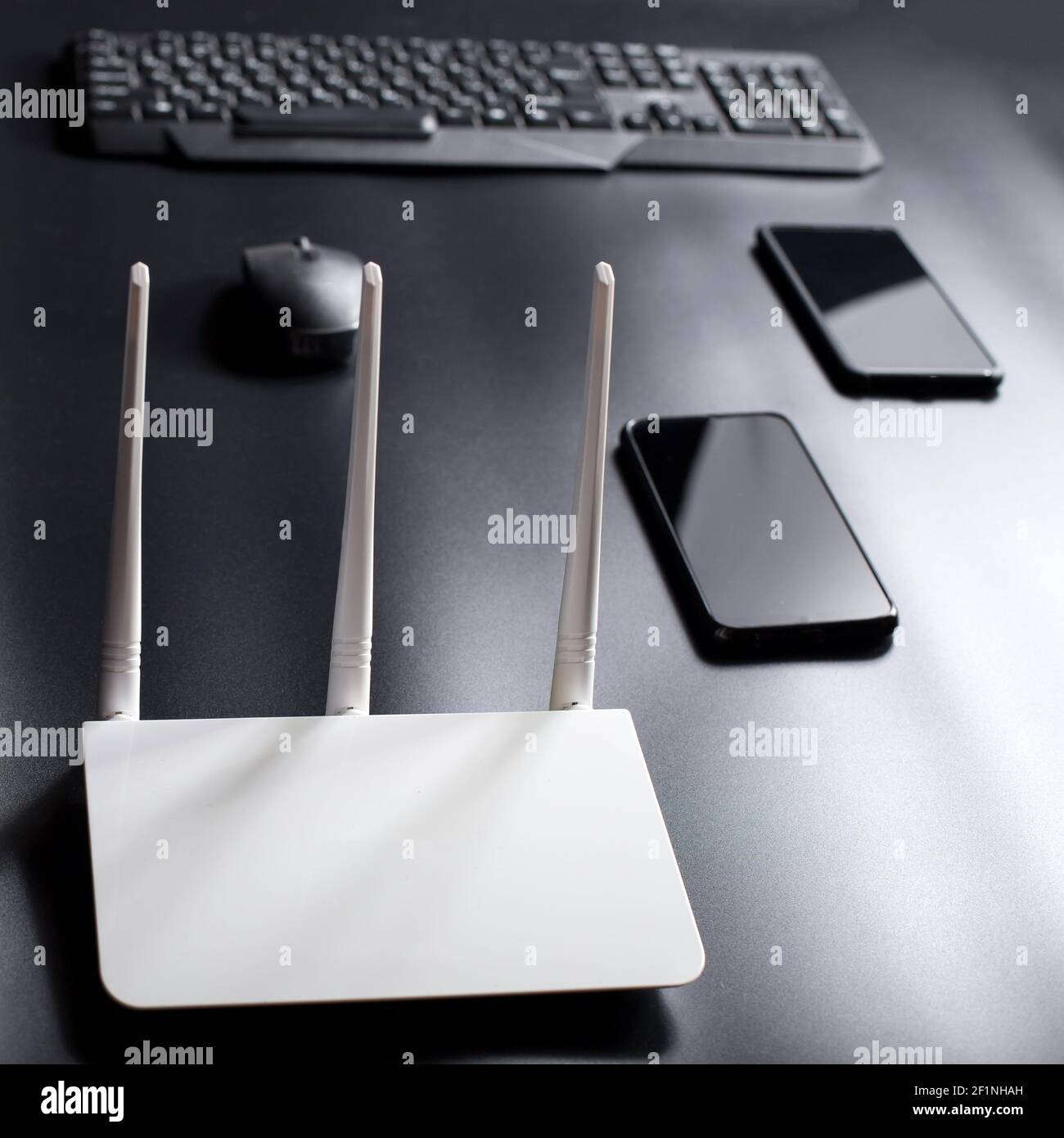 Whhite wifi router close up on black background with smartphones and PC ...