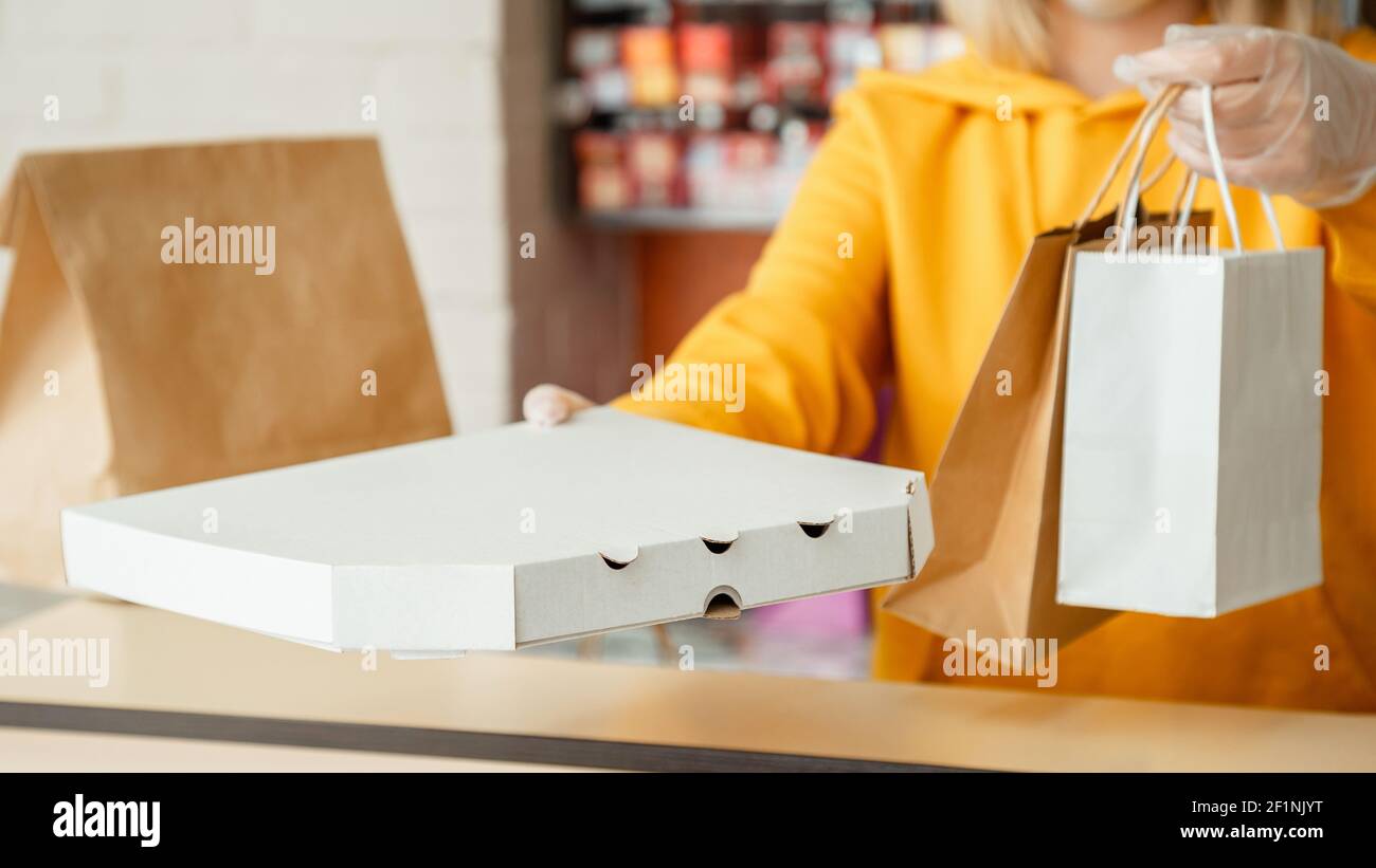 Pizza to go, takeaway Pizza coffee, Food delivery. Woman in gloves work ...