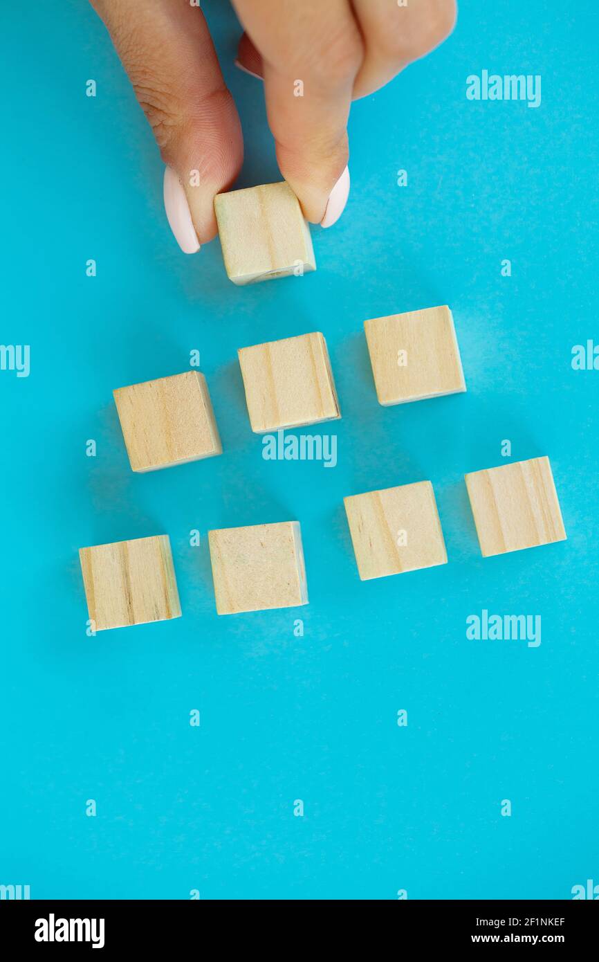 Woman hand putting and stacking blank wooden cubes on desk with copy ...