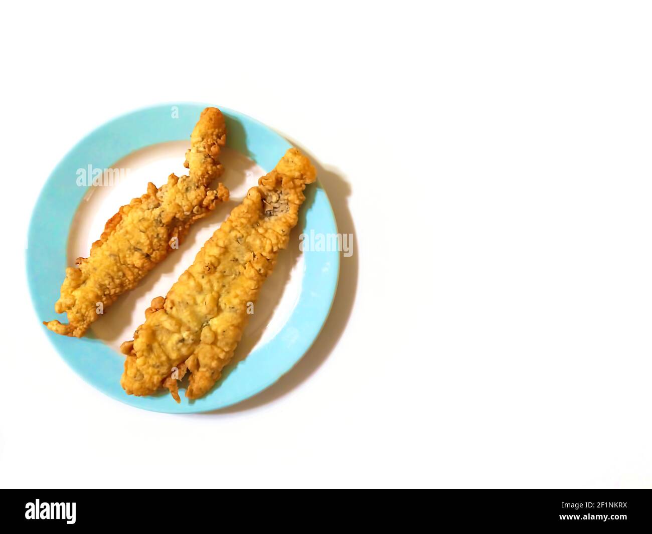 Overhead shot of fresh tasty fried battered hake fish filet on a plate ...