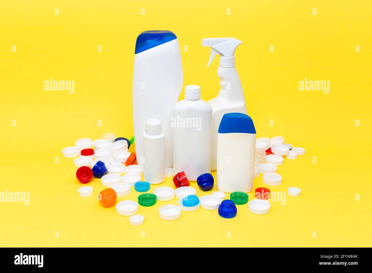 Different plastic containers isolated on yellow background. Recycling ...