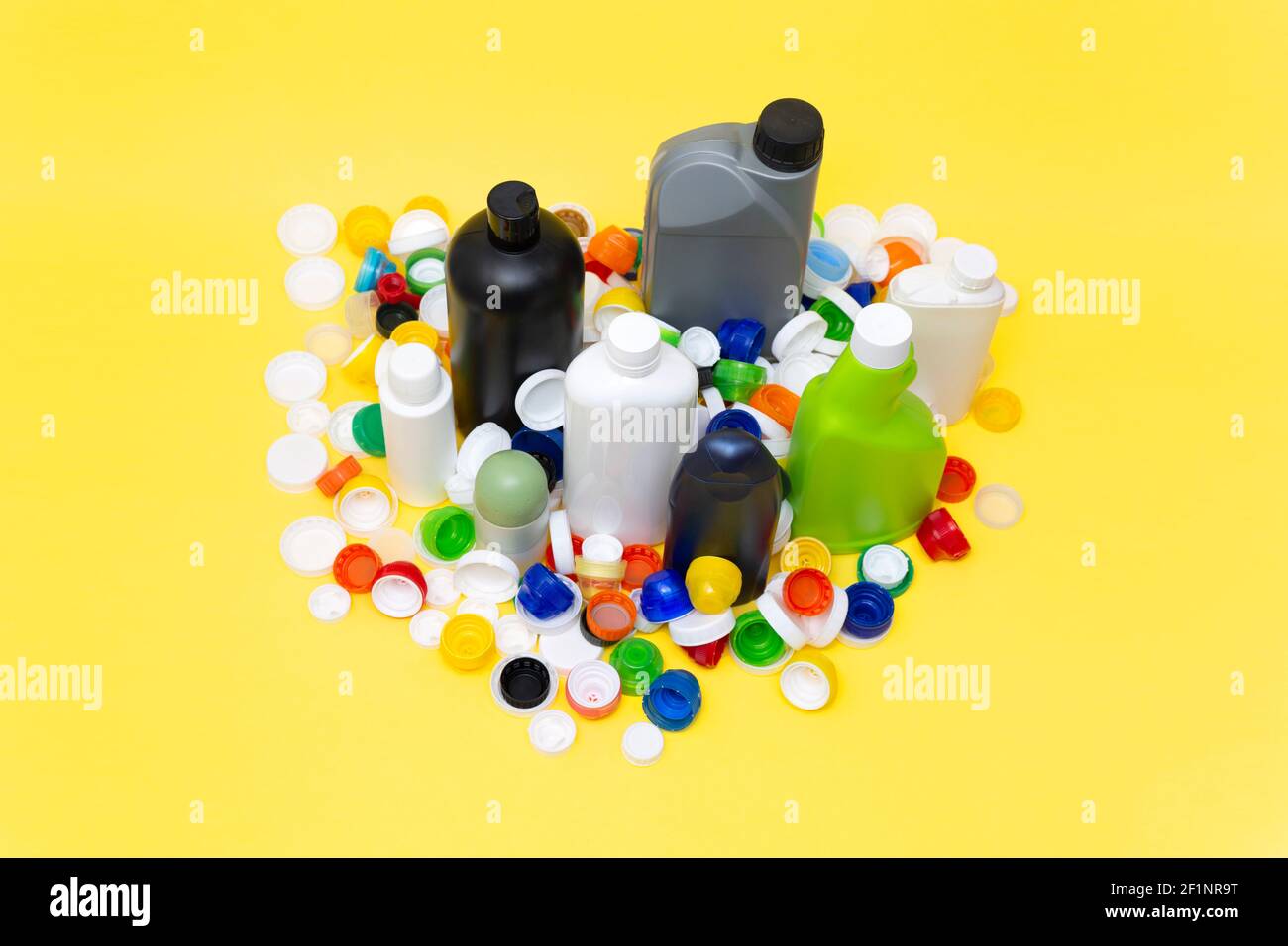Various plastic containers of different sizes and shapes and many caps ...