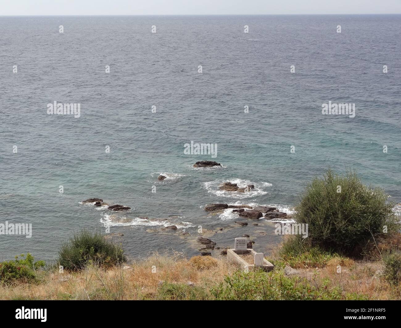 View from a cliff to blue sea with rocks at the coast line. Beautiful ...