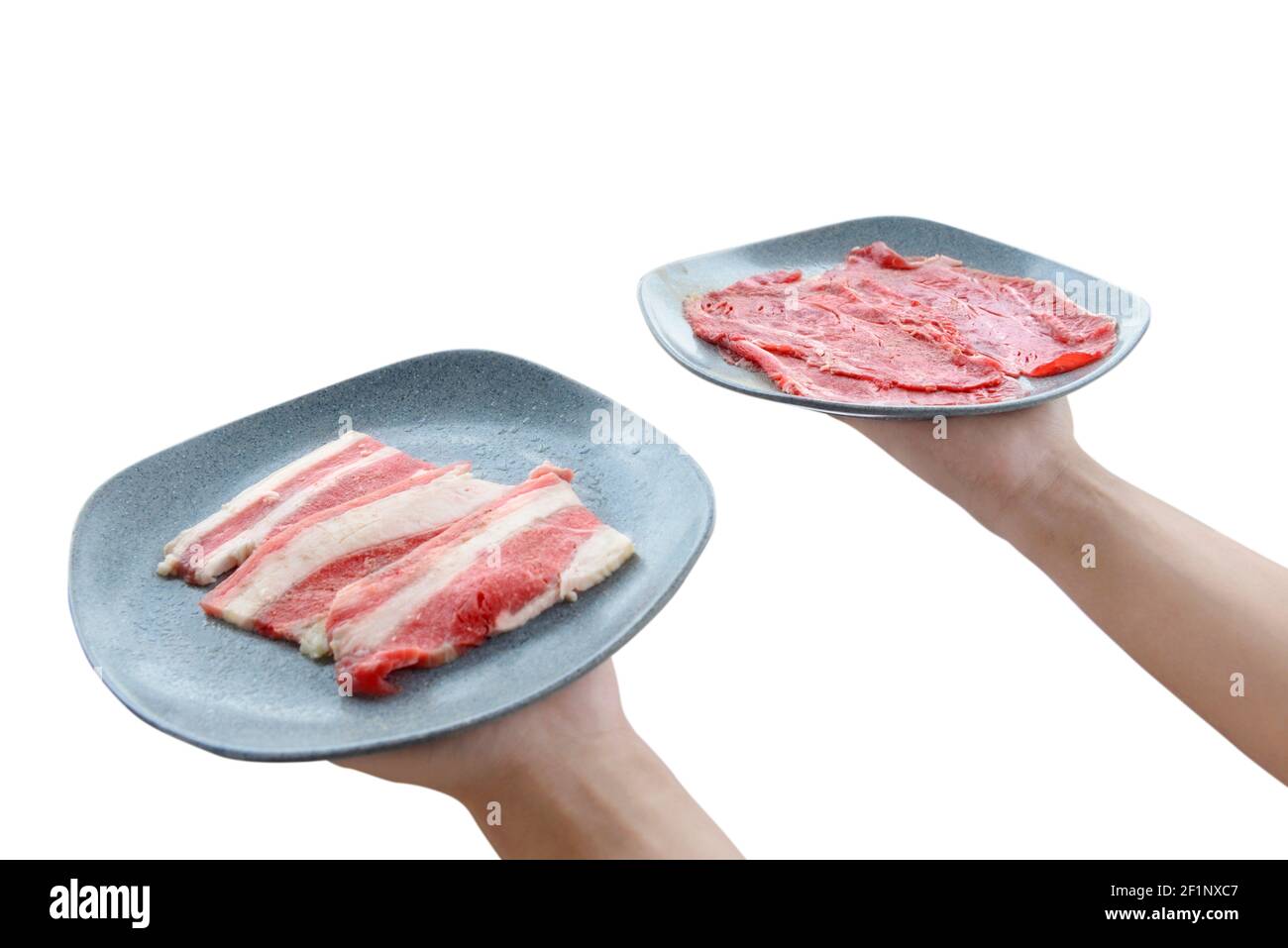 Human hand holding a plate with raw meat for grilled isolated over ...