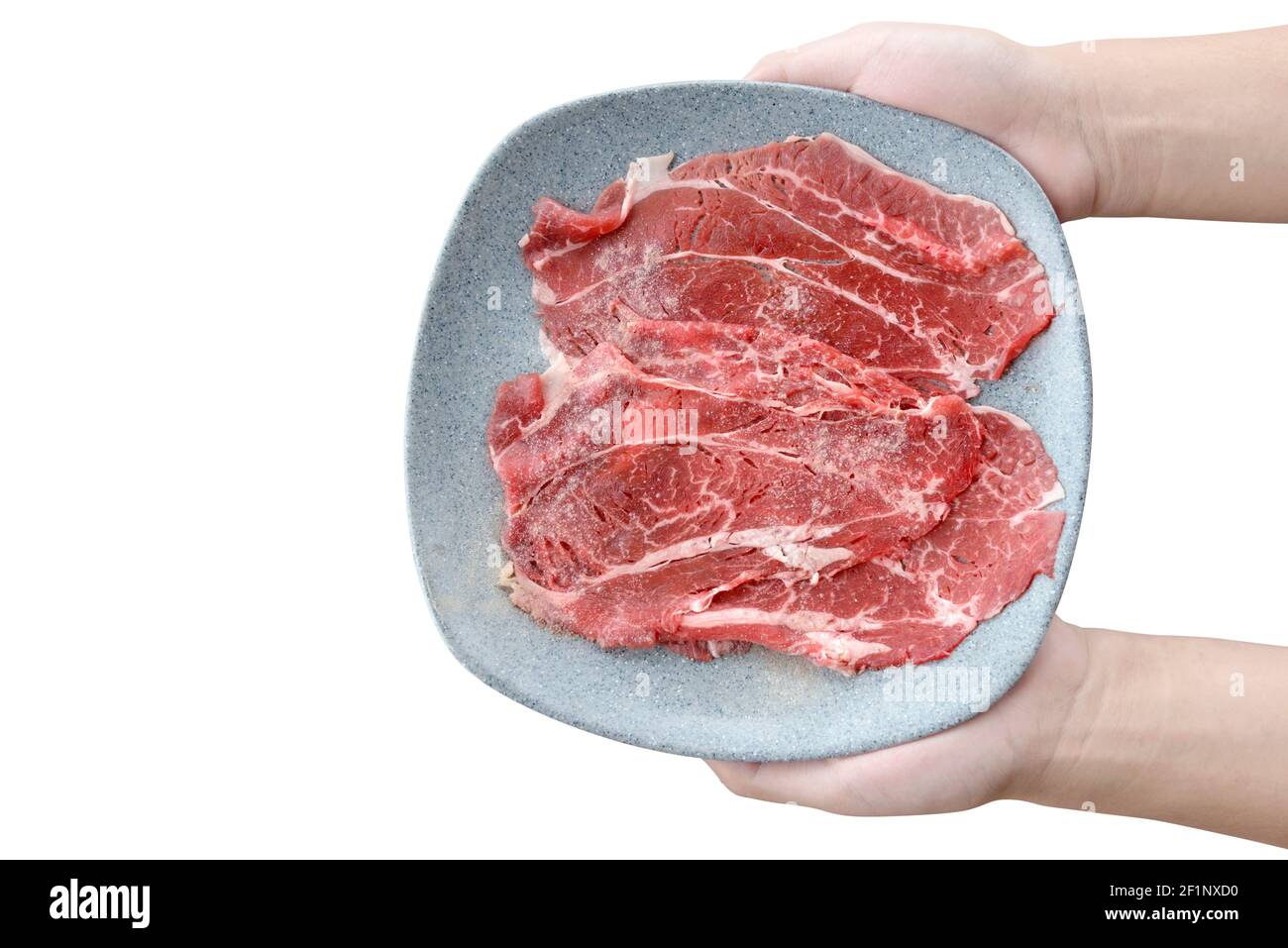 Human hand holding a plate with raw meat for grilled isolated over ...