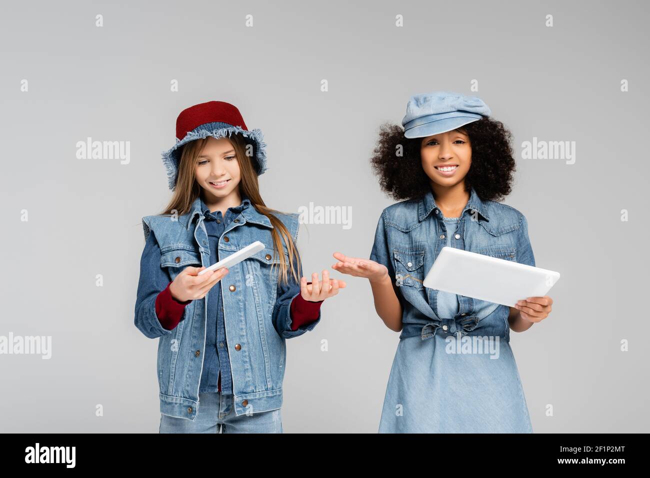 skeptical and smiling multicultural friends showing shrug gesture while ...