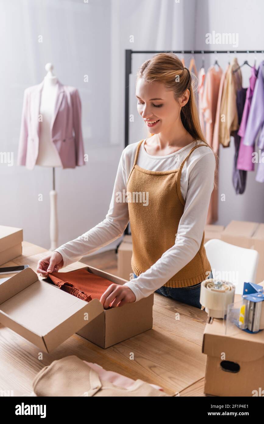 happy fashion boutique owner packing cardboard boxes at workplace Stock ...