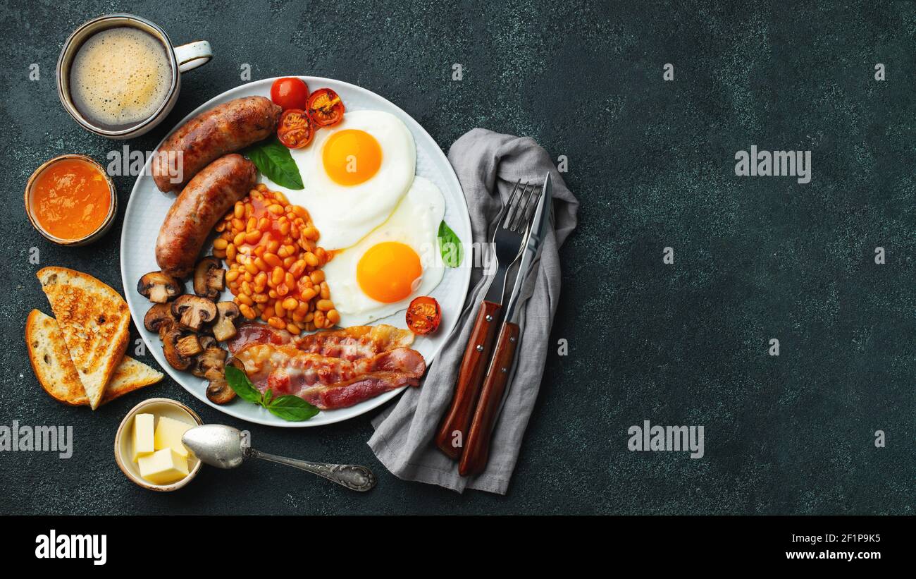 Full English breakfast on a plate with fried eggs, sausages, bacon ...