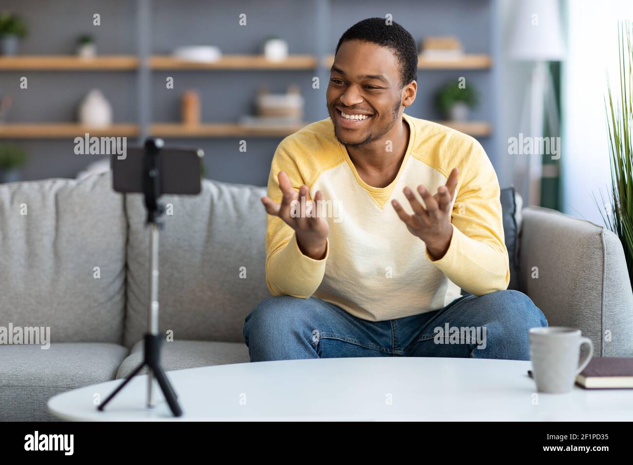 Cheerful young african american man influencer broadcasting from home ...