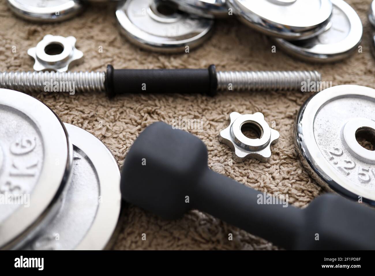 Pile of shiny chrome dumbbells disks lying around grip Stock Photo - Alamy