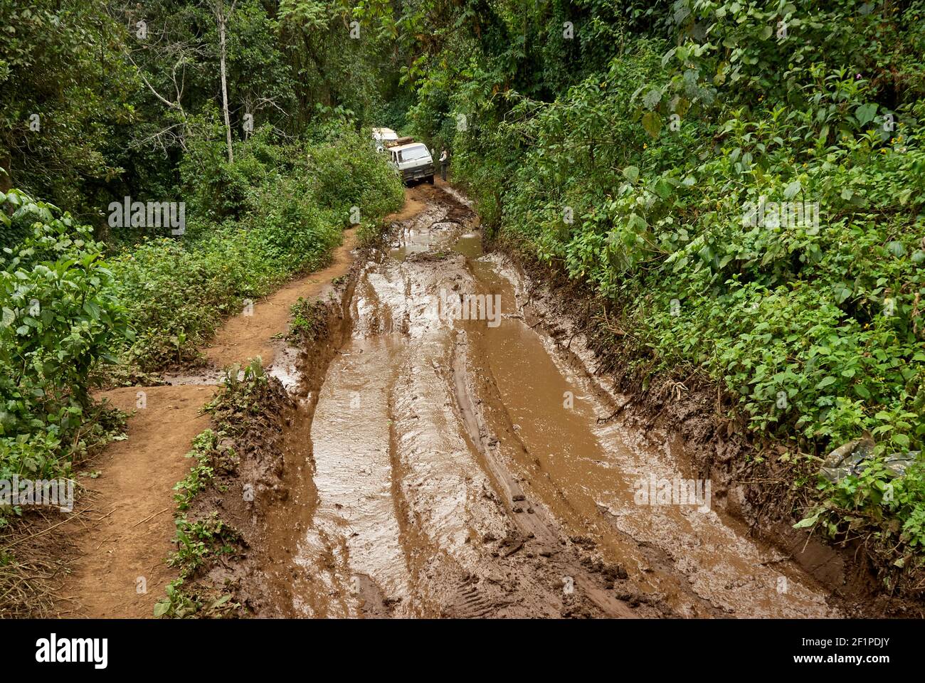 heavy baggage loaded Minibus carry ports, car in front of a mud pool ...