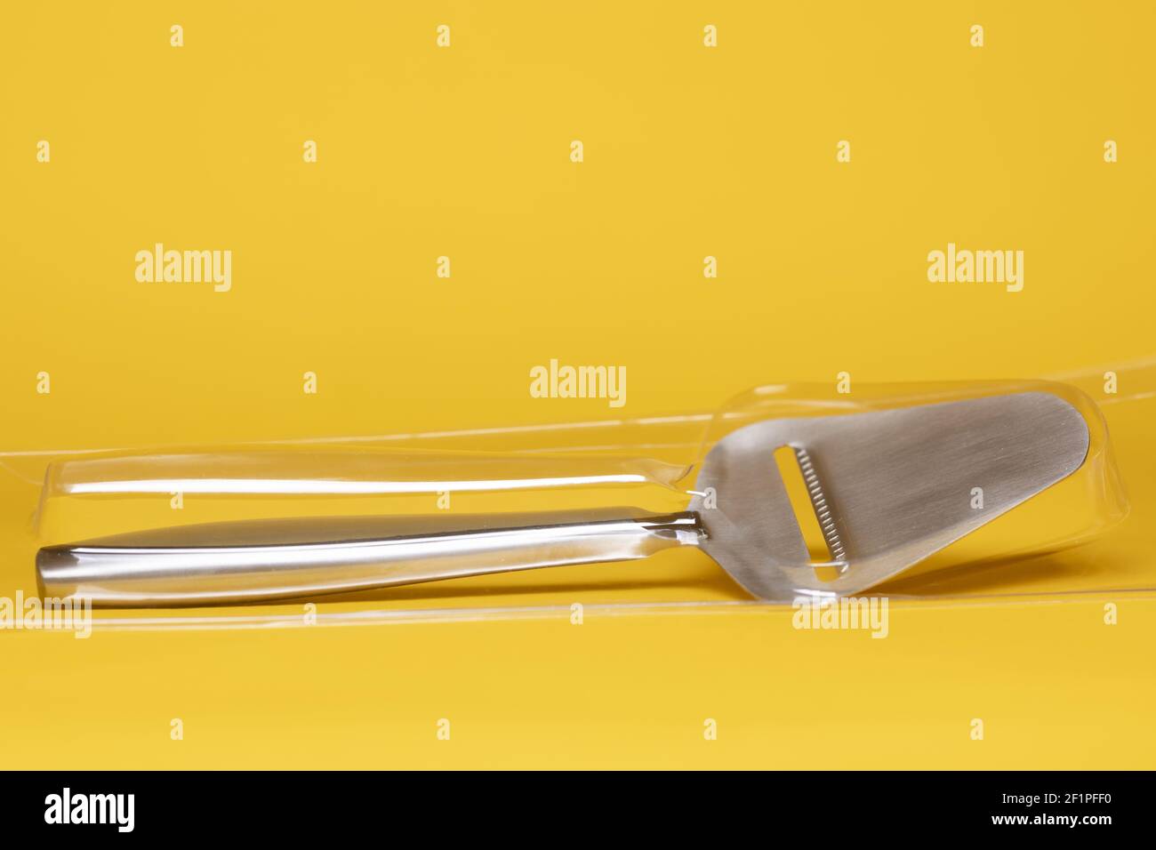 Shiny plastic mold wrapper with cheese slicer Stock Photo - Alamy