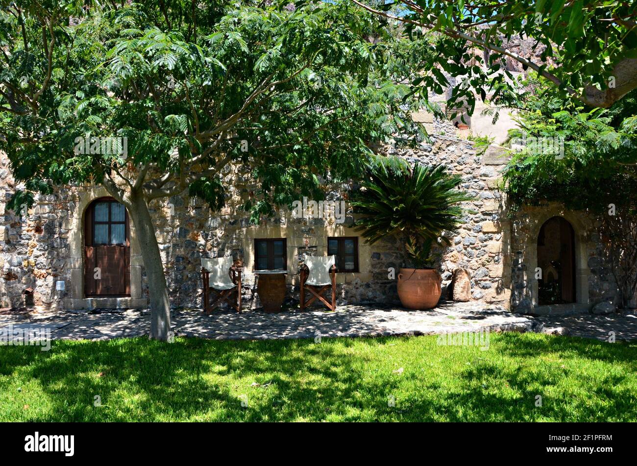 Traditional stone houses facade and patio view with wicker furniture in ...