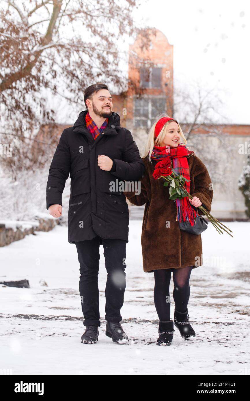 Young handsome guy and girl with a bouquet of roses walking on ...