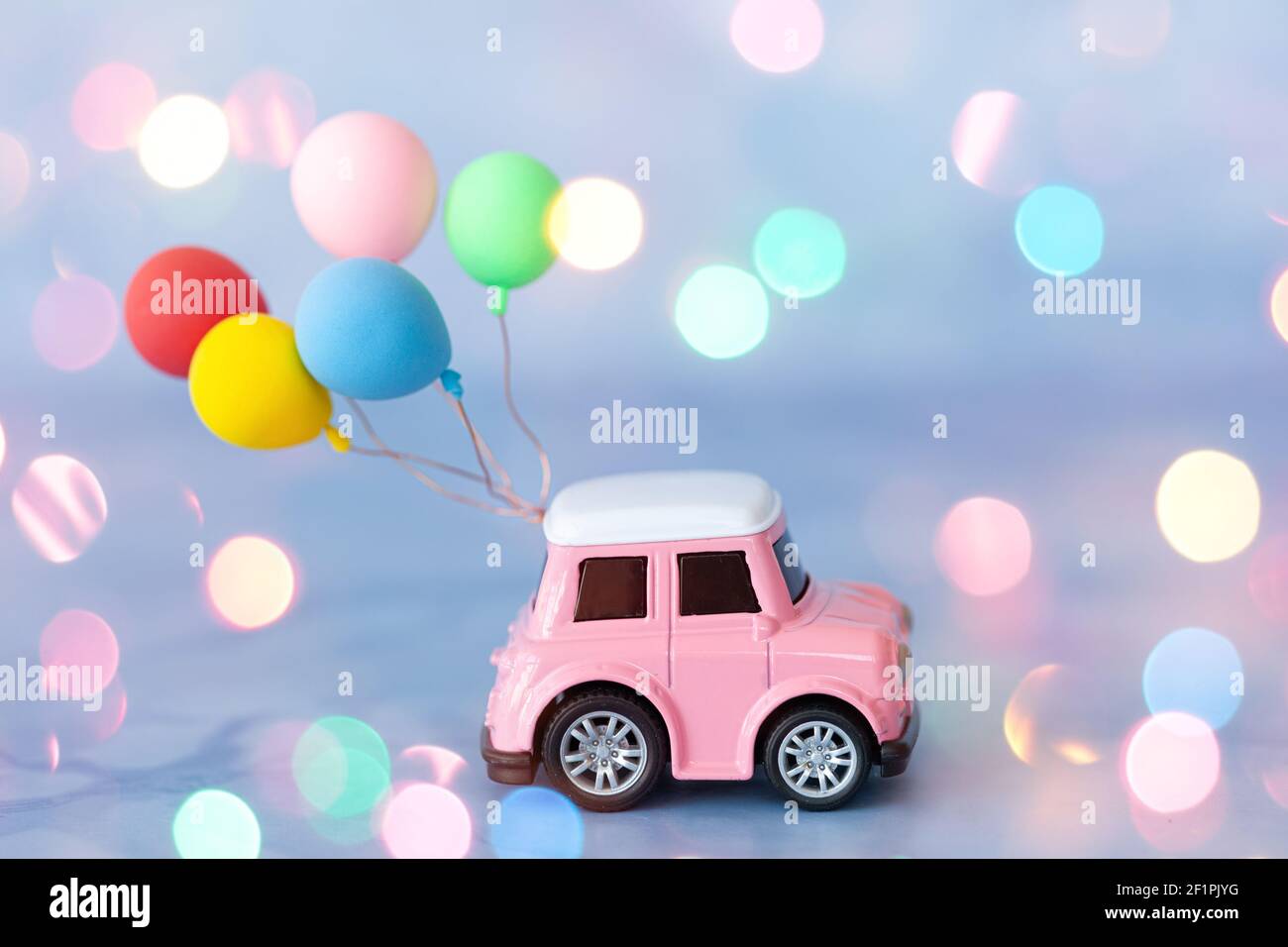 Small pink car with balloons Stock Photo - Alamy