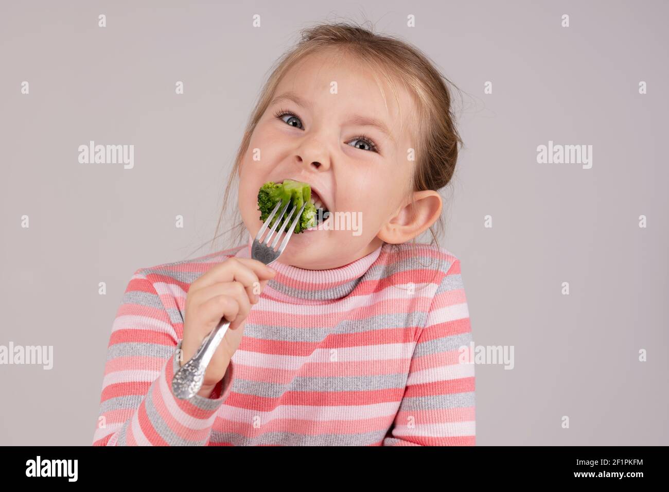 The child eats broccoli with undisguised disgust. High quality photo ...