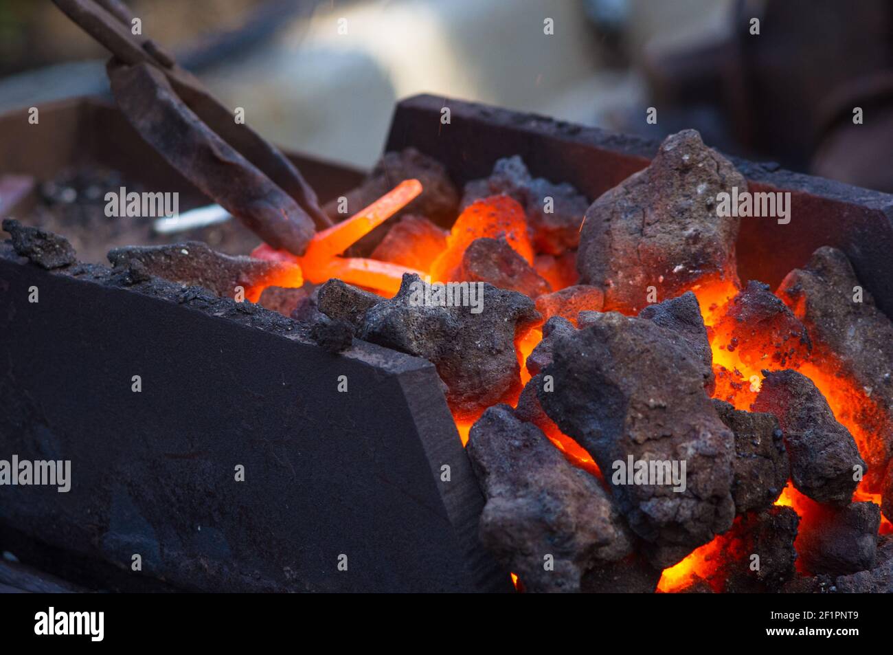 blacksmith furnace with burning coals, tools, and glowing hot metal ...