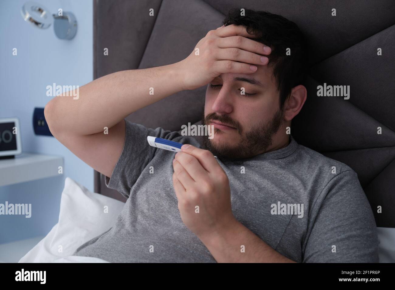 Sick person with thermometer in bed hi-res stock photography and images ...