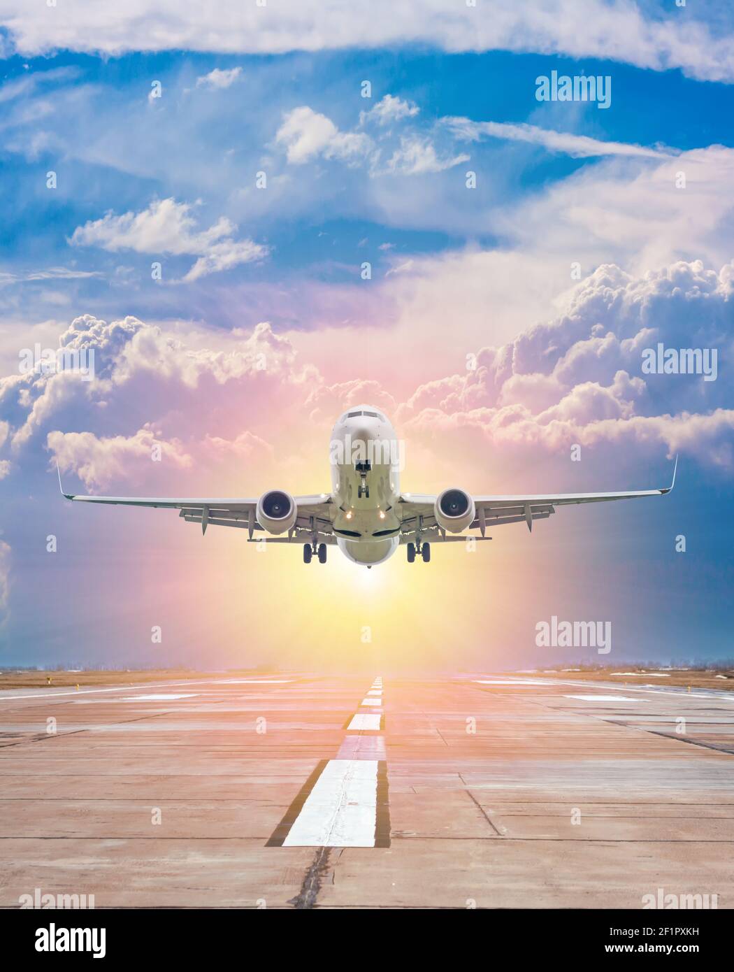 White passenger aircraft take off from airport runway against the ...