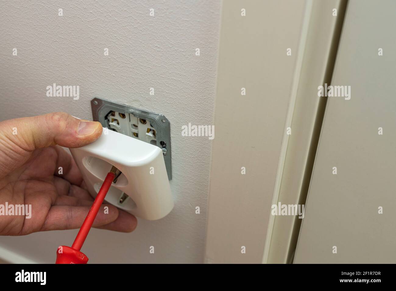 Close up view of man repairing white light switch. Electricity concept ...