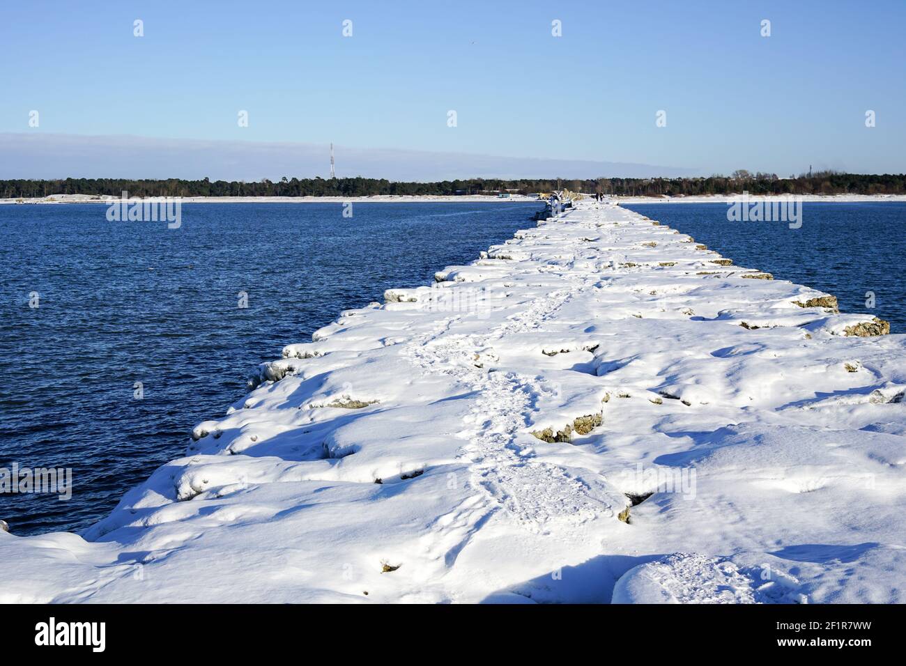 winter seascape, port entrance with snow covered concrete blocks ...