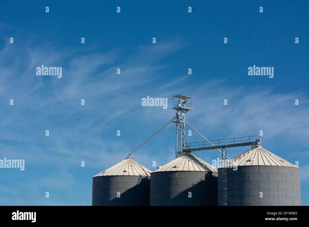 Top of three grain storage silos with copy space, blue sky on top ...