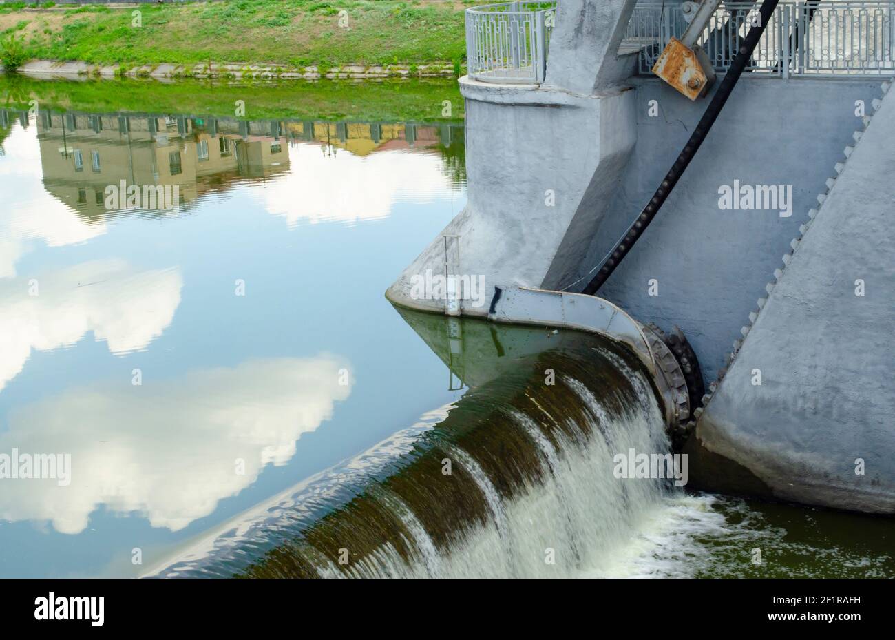 Reflection of the city in the river near the water dam. Inverted ...