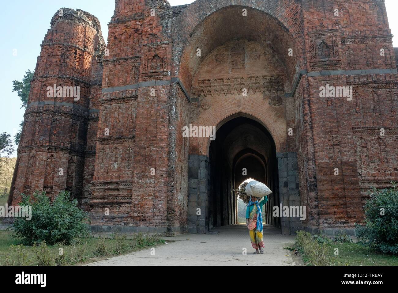 Gour, India - January 2021: A woman carrying firewood near the Dakhil ...