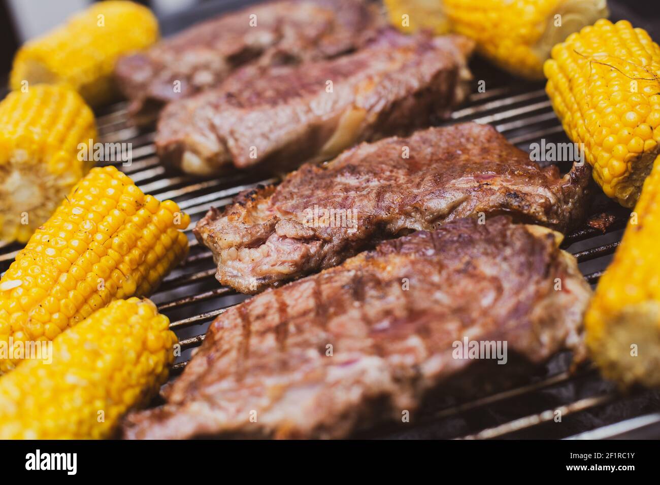 Beef steaks and corn cobs are grilled on the grill Stock Photo - Alamy