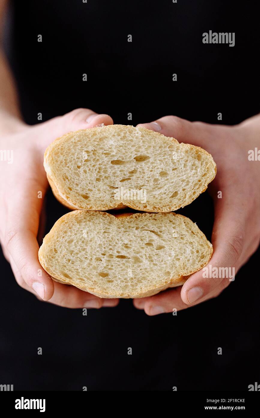 men's hands hold sliced bread on a dark background Stock Photo - Alamy