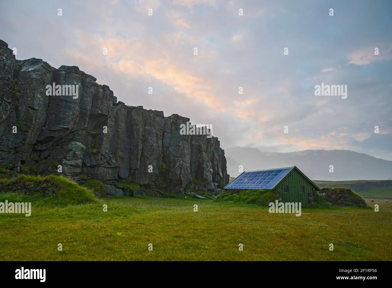 shed underneath basalt cliff in Iceland Stock Photo - Alamy
