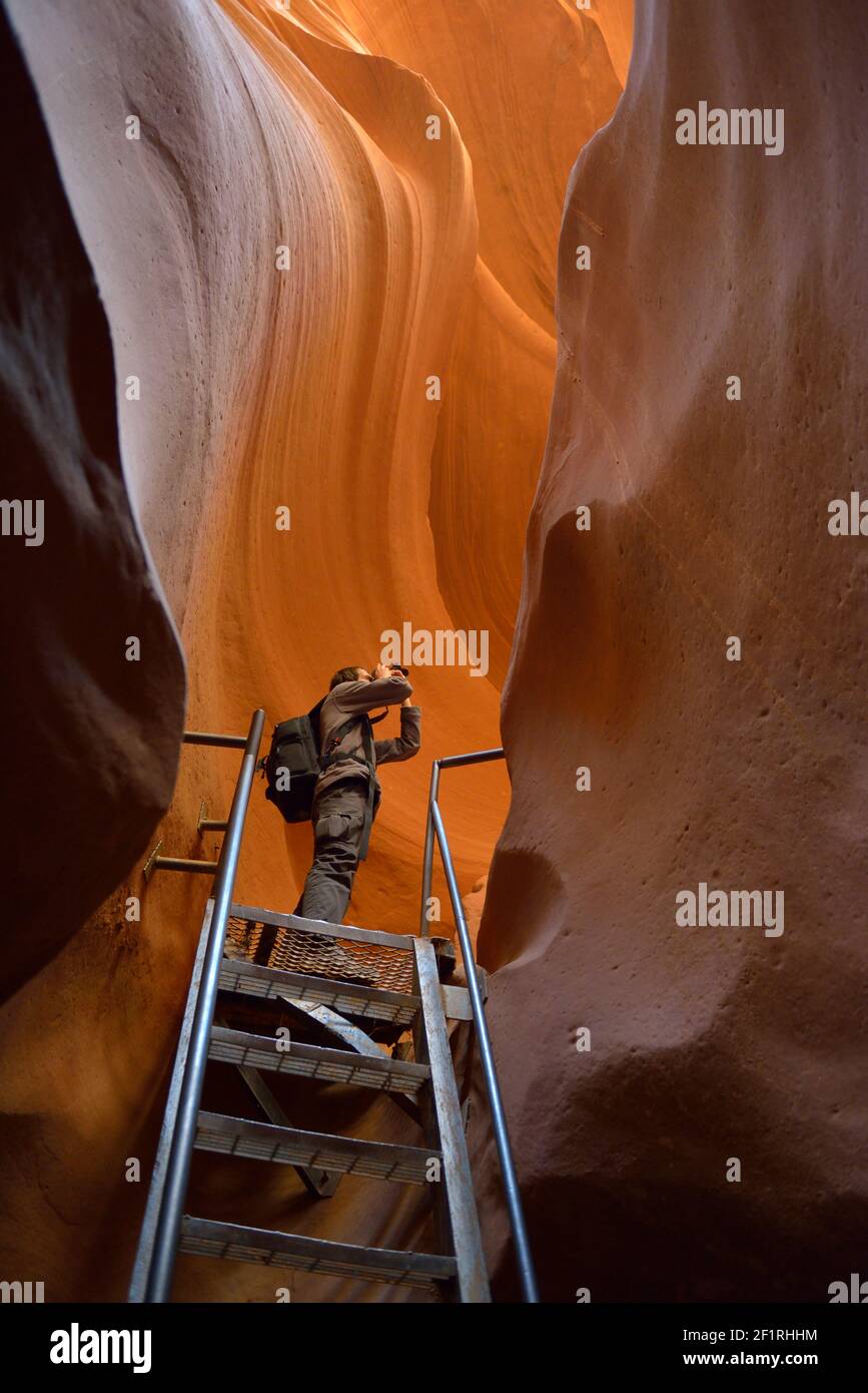 Tourist taking photos at the top of a ladder, Lower Antelope Canyon ...