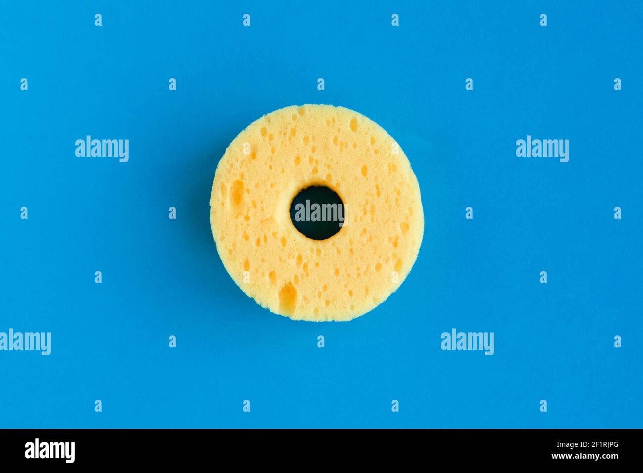 Round yellow sponge for washing dishes on blue background. Minimal ...