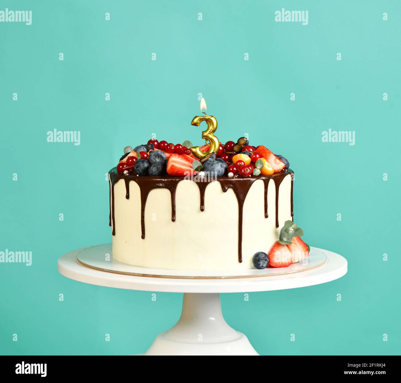 Three years old Birthday party sweet cake with chocolate drips and ...