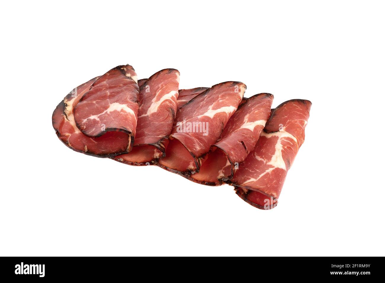 Folded pieces of dry-cured pork neck on a white background. Copy space ...